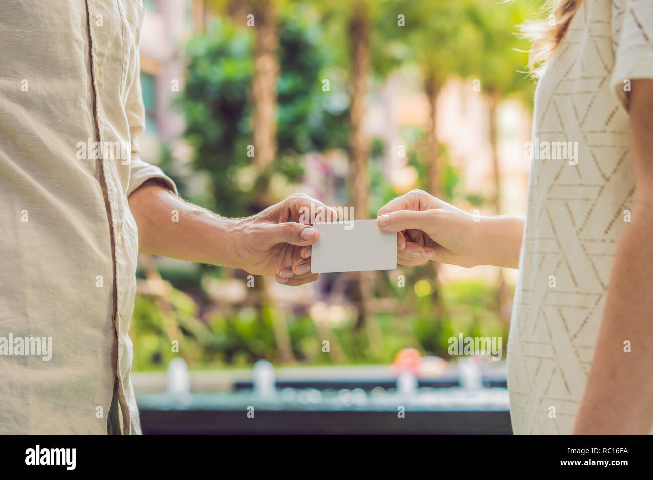 A woman gives to a man security key card or business card Stock Photo ...