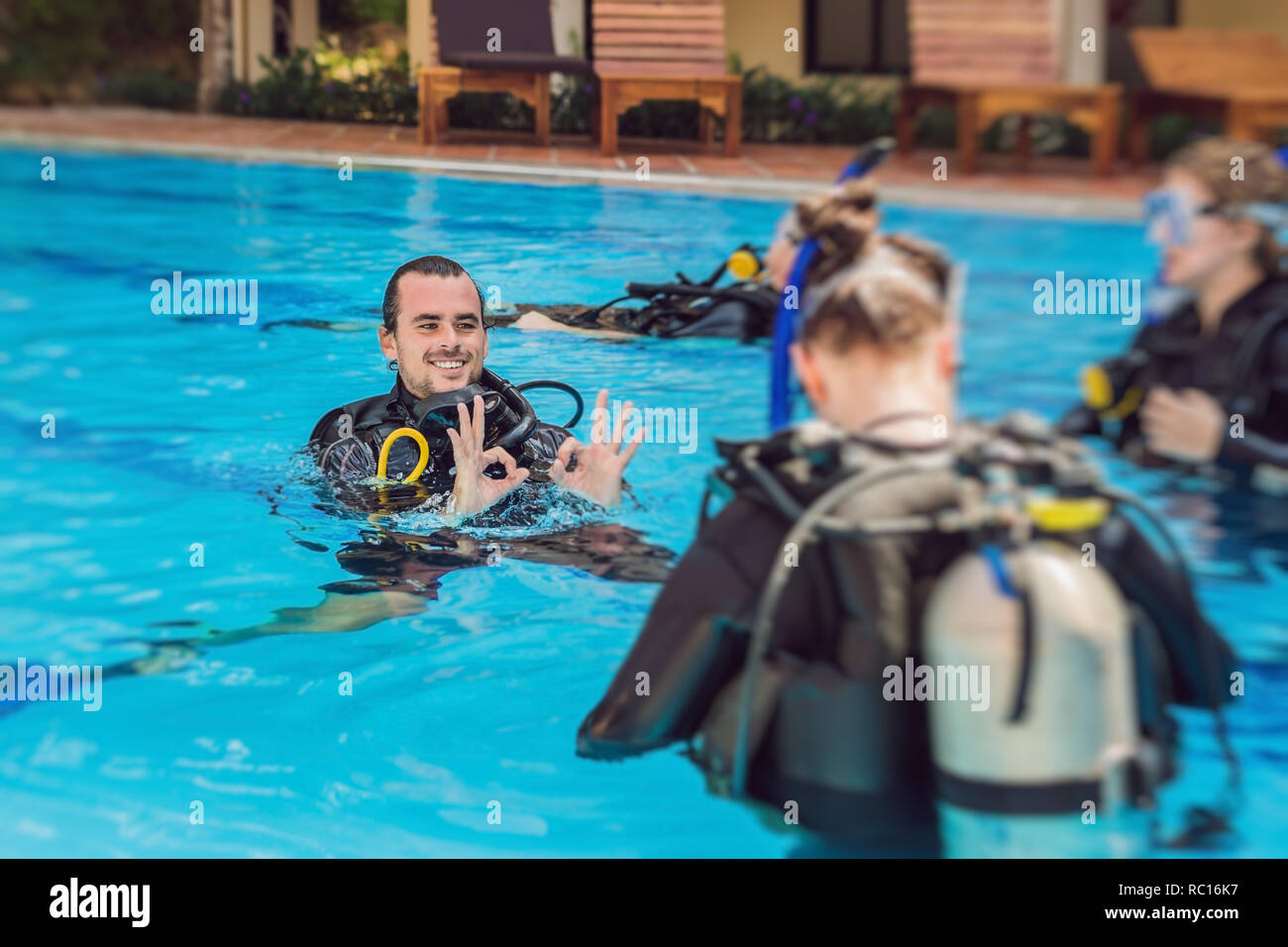 Diving instructor and students. Instructor teaches students to dive ...
