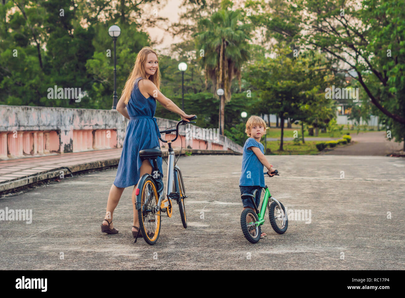 Happy family is riding bikes outdoors and smiling. Mom on a bike and ...
