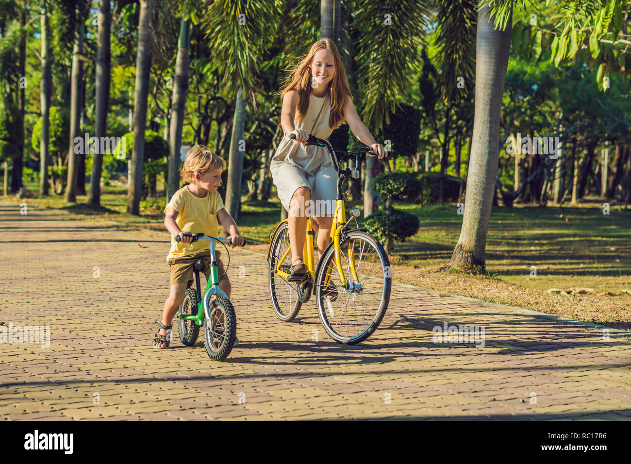 Happy family is riding bikes outdoors and smiling. Mom on a bike and ...