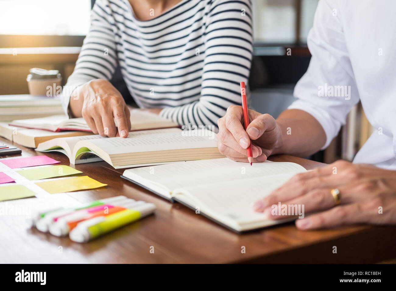 Young students classmates help friend catching up workbook and learning ...