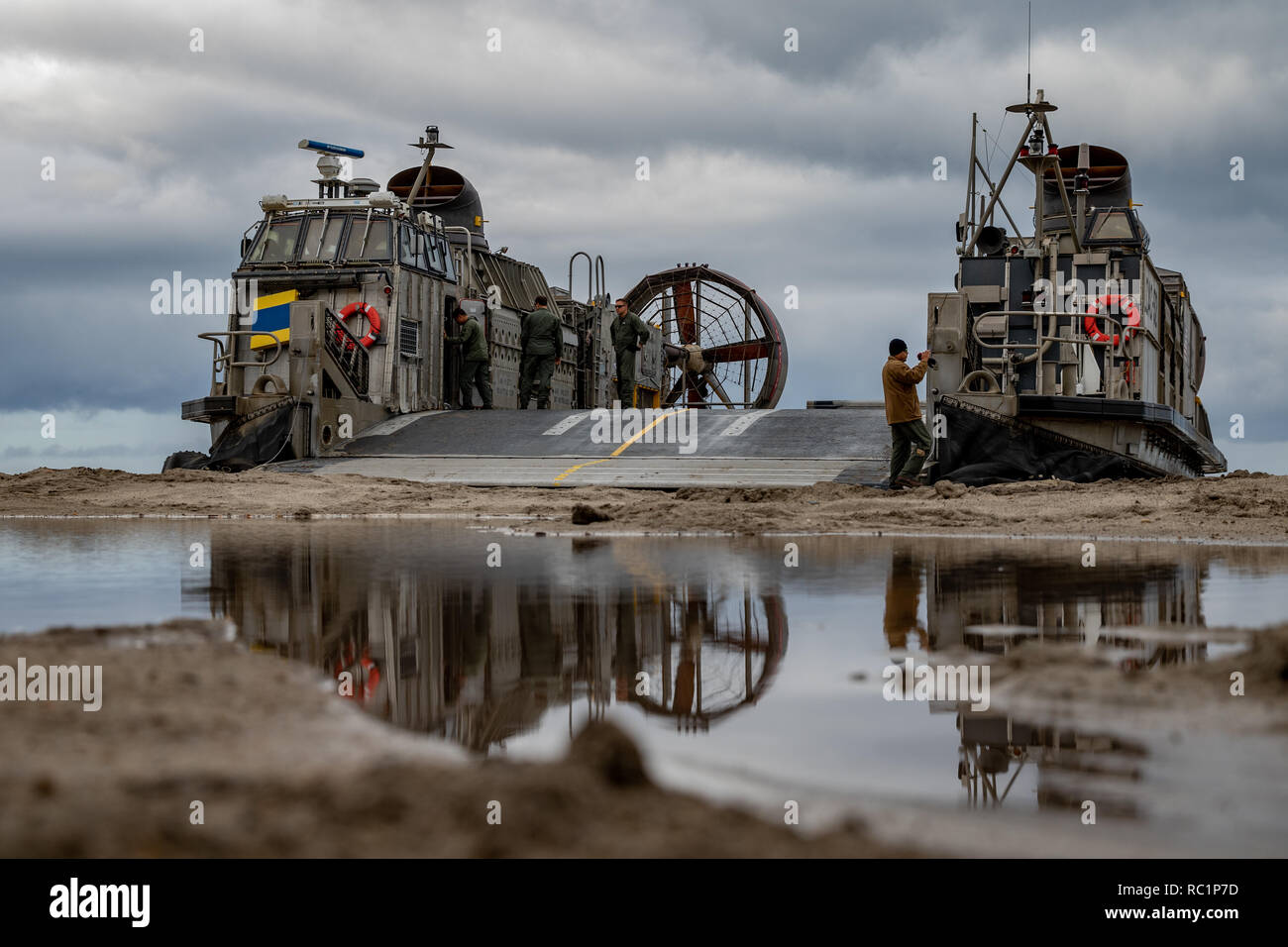 U.S. Sailors with Assault Craft Unit 5, prepare a landing craft air ...