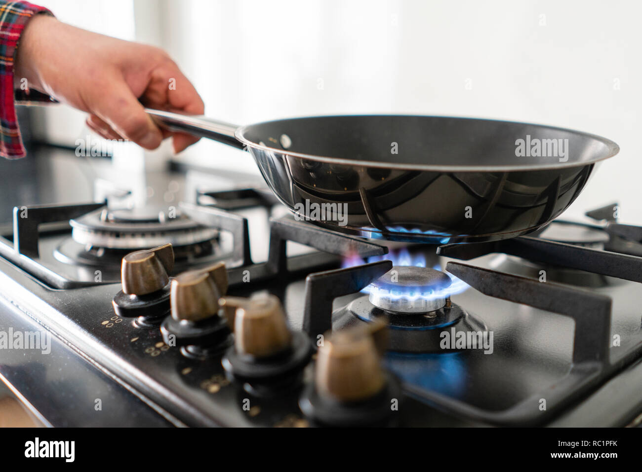 Closeup shot of blue fire from domestic kitchen hob. Gas cooker with ...