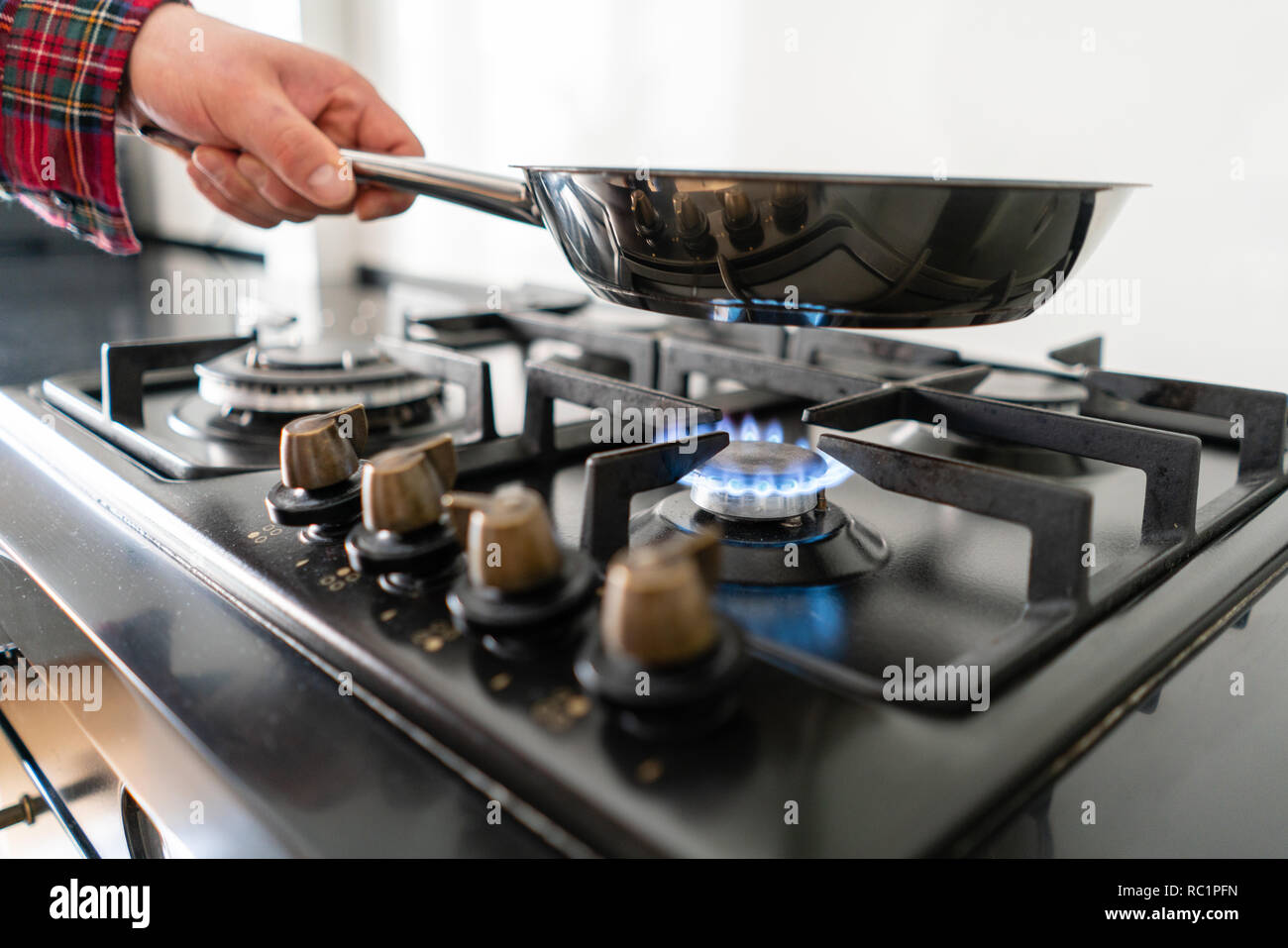 Closeup shot of blue fire from domestic kitchen hob. Gas cooker with ...