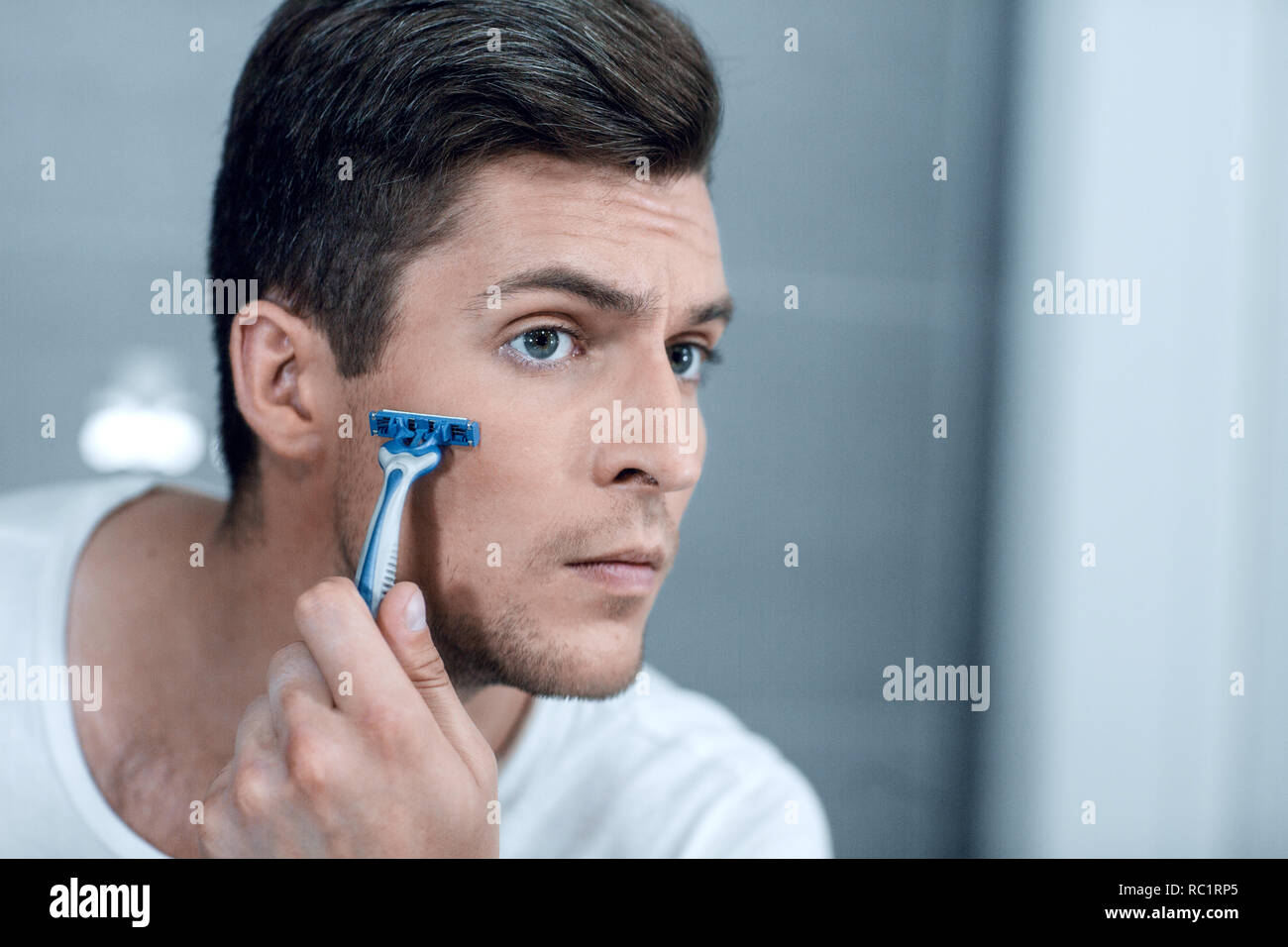 Young man shaves beard standing hi-res stock photography and images - Alamy