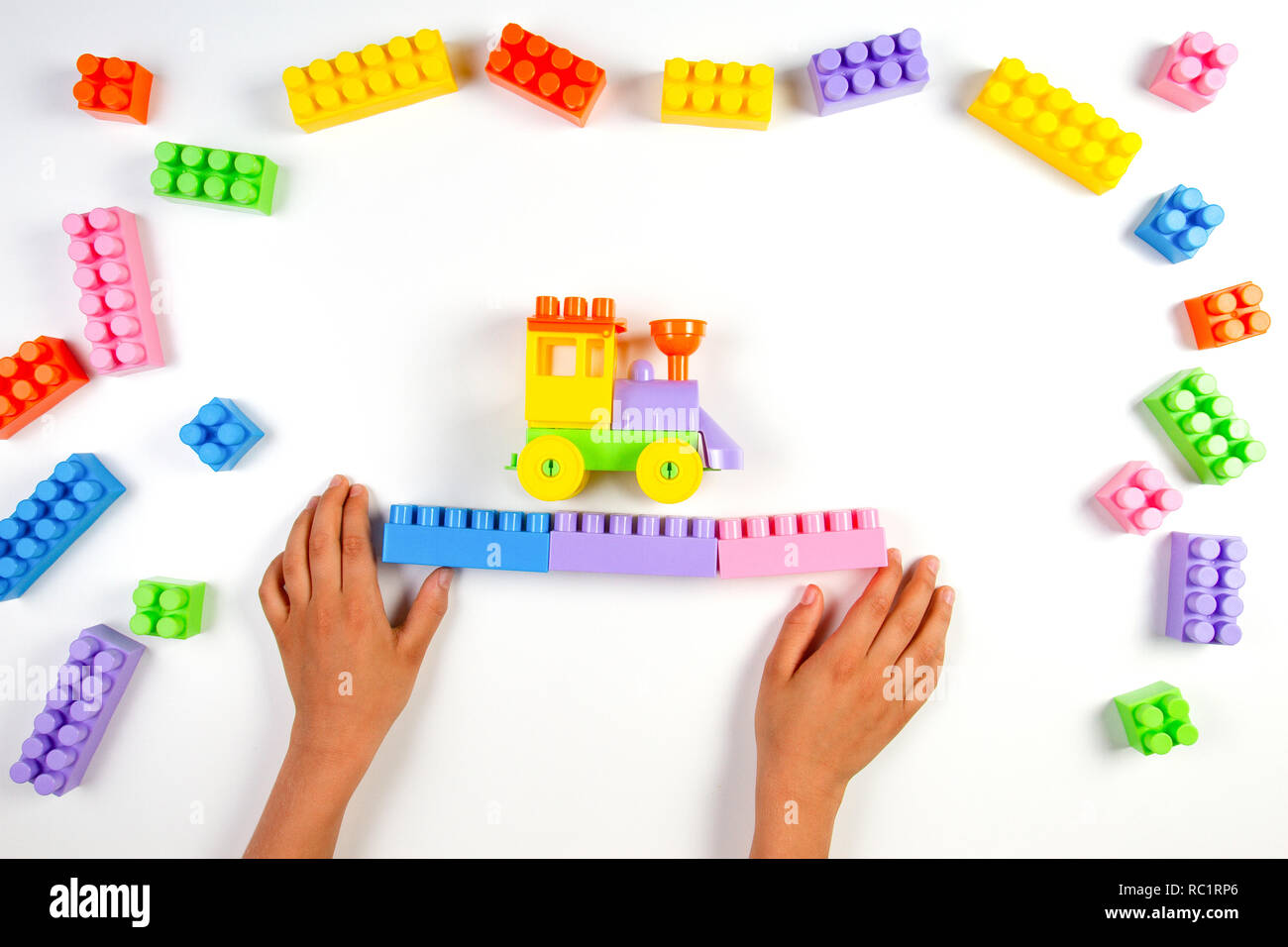 Kid hands play with colorful plastic construction blocks and train on ...