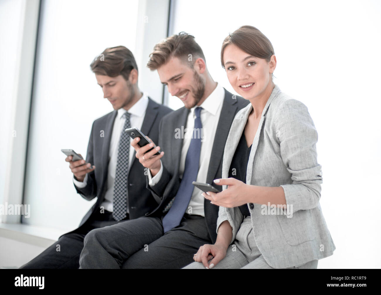 smiling employees using their smartphones Stock Photo - Alamy