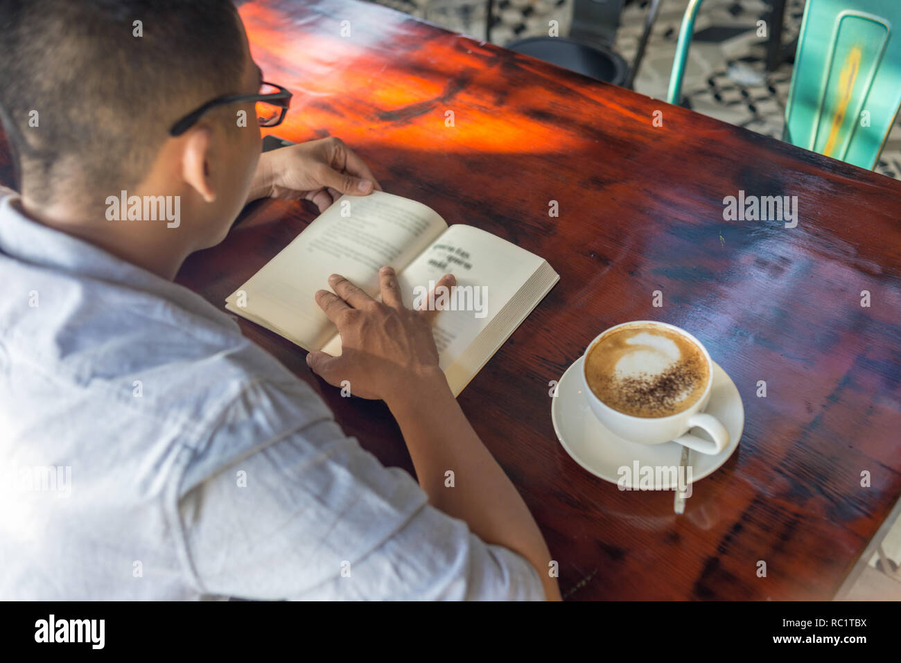 Young man reading books in the morning Stock Photo - Alamy