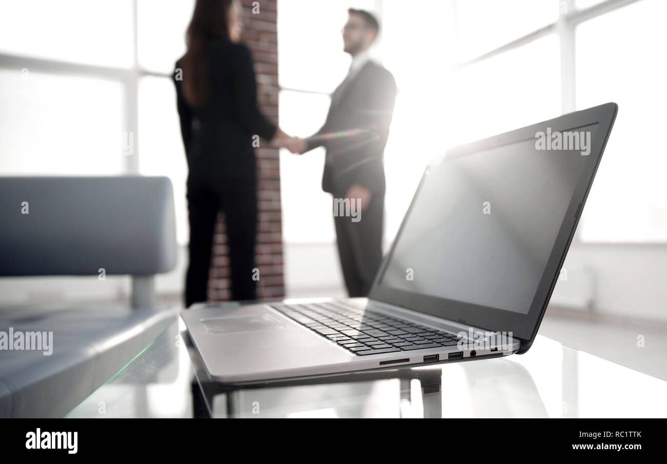 laptop on the desk, background handshake Stock Photo - Alamy