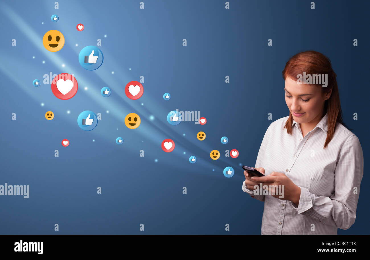 Young person using smartphone with flying social media icons around ...
