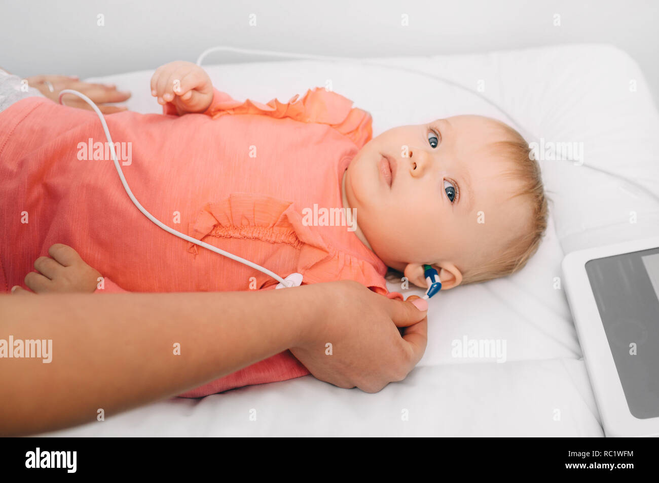 doctor check a baby girl's ears. Little baby having hearing test ...