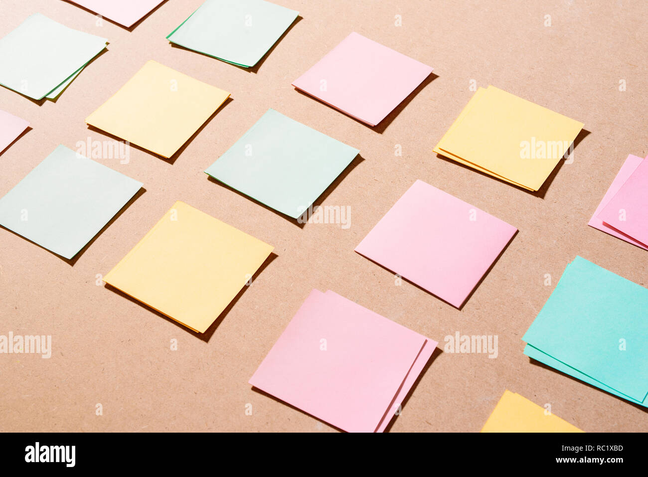 Multi colored notepads laying on a wooden plank board surface with copy ...
