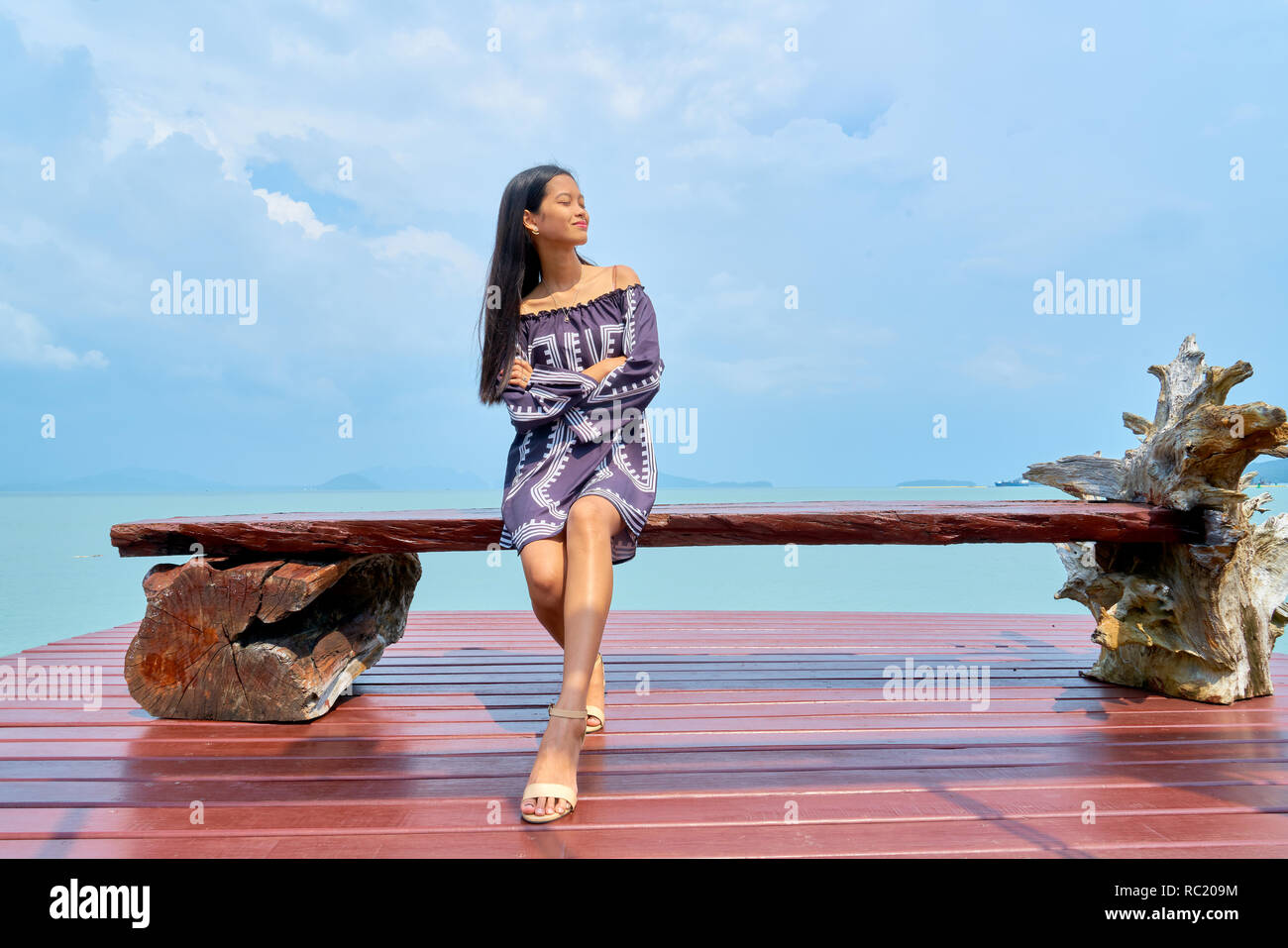 Beautiful woman posing - sitting on bench, cross arms, refreshing and ...