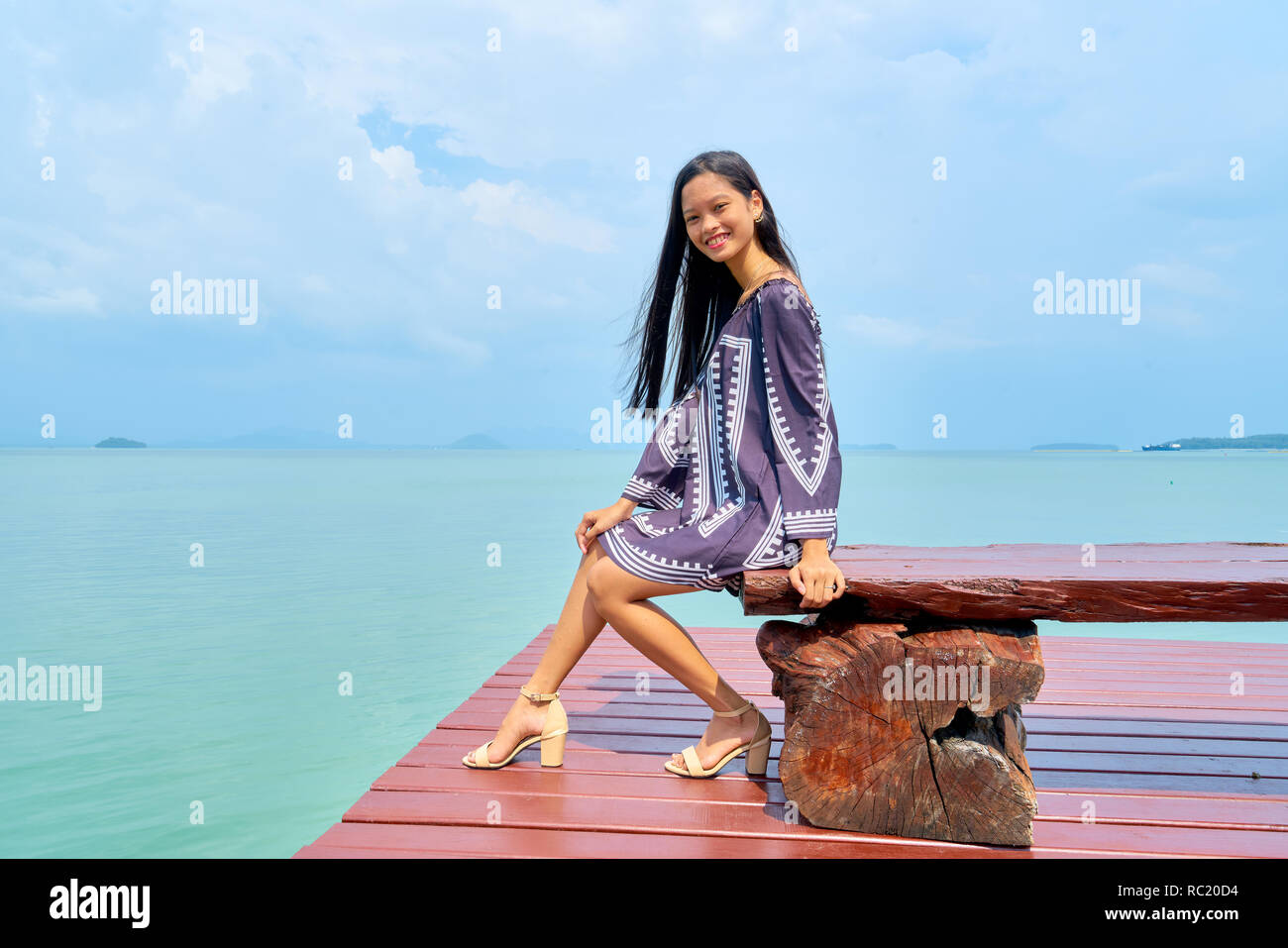 Beautiful woman posing - side view sitting on bench and happy Stock ...