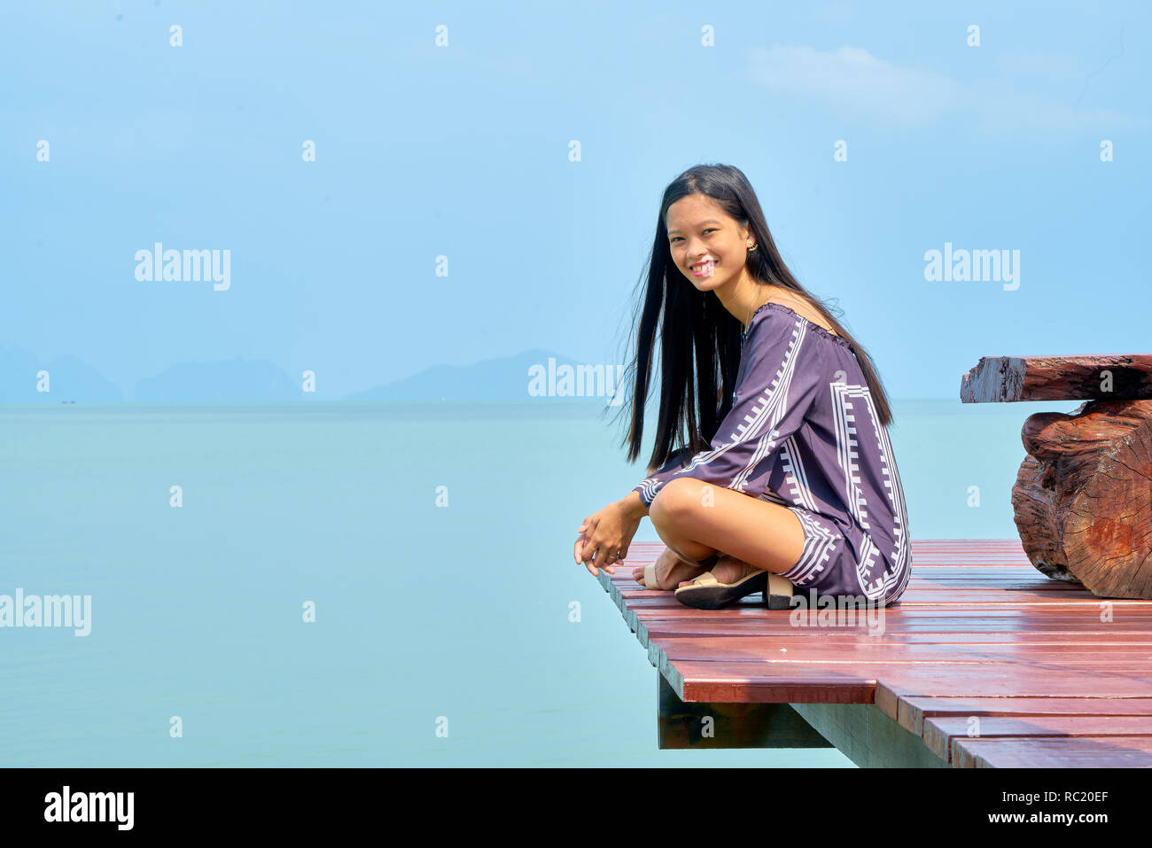 Beautiful woman posing - sitting side view and enjoying Stock Photo - Alamy