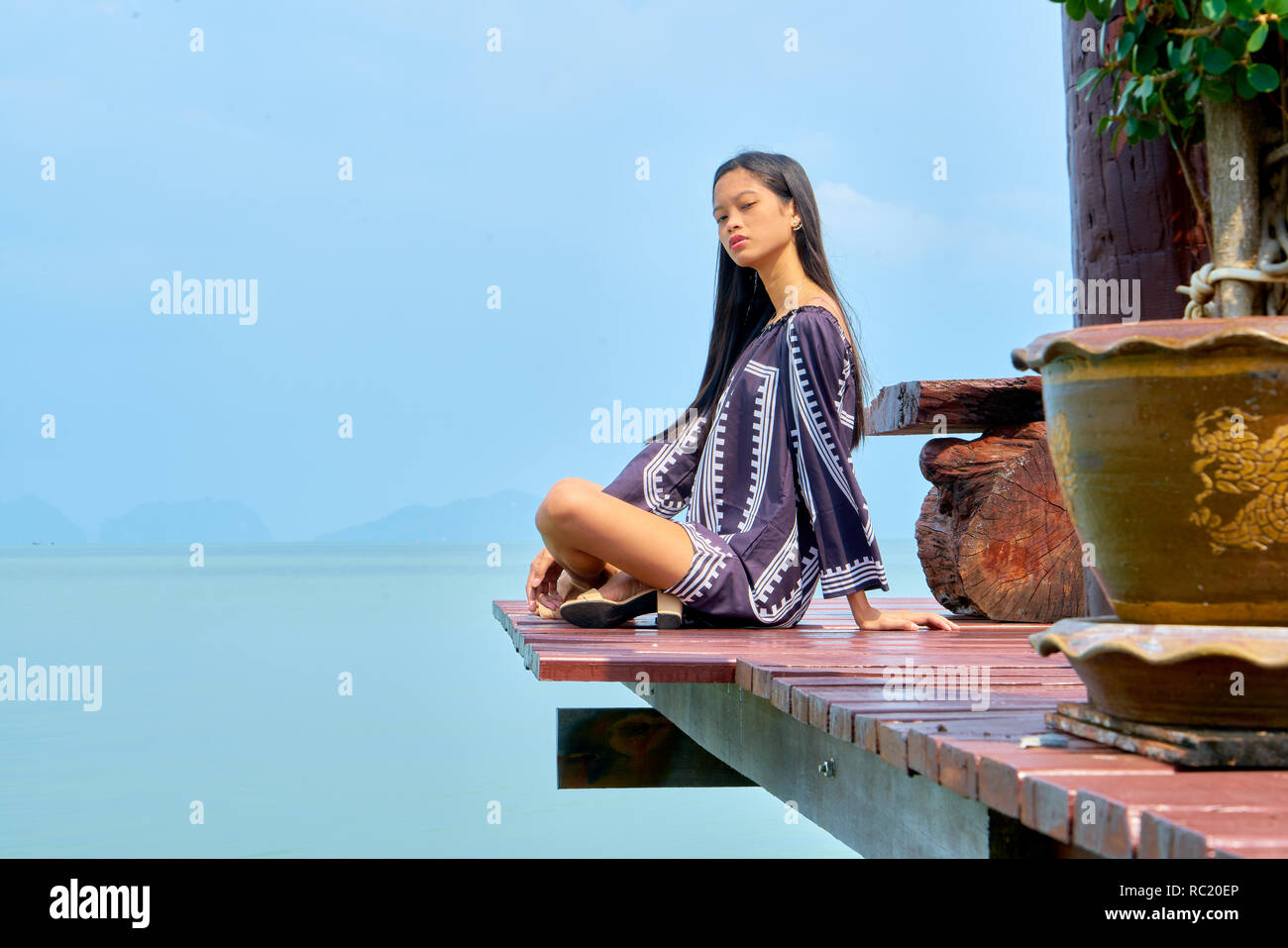 Beautiful woman posing - sitting side view, looking at camera and ...