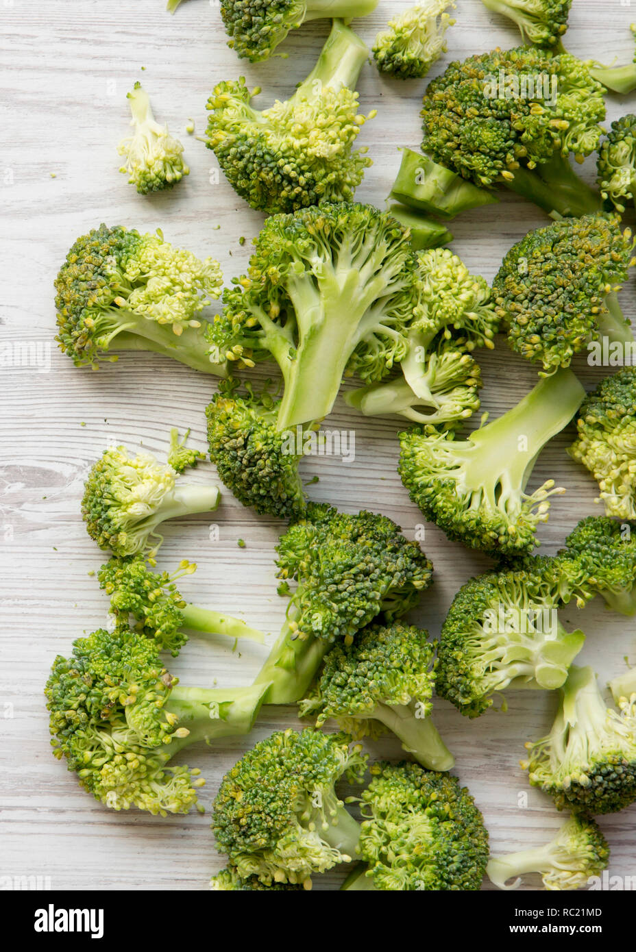 Chopped raw broccoli on white wooden background, overhead view. From ...