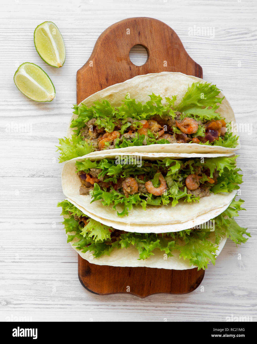 Shrimp tacos on wooden board on white wooden surface, top view. Mexican ...
