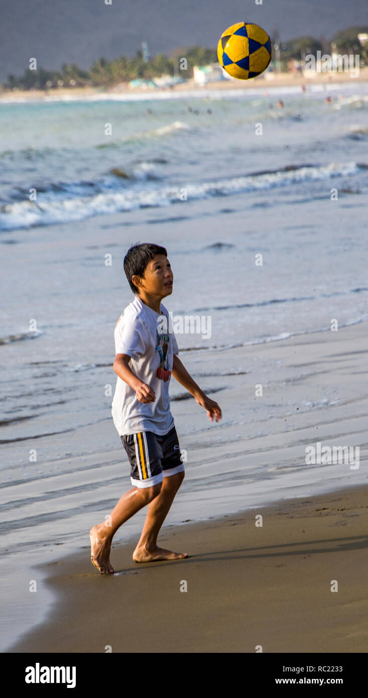 Puerto Lopez, Ecuador / August 19, 2016 - Boy plays soccer (futbol) on ...