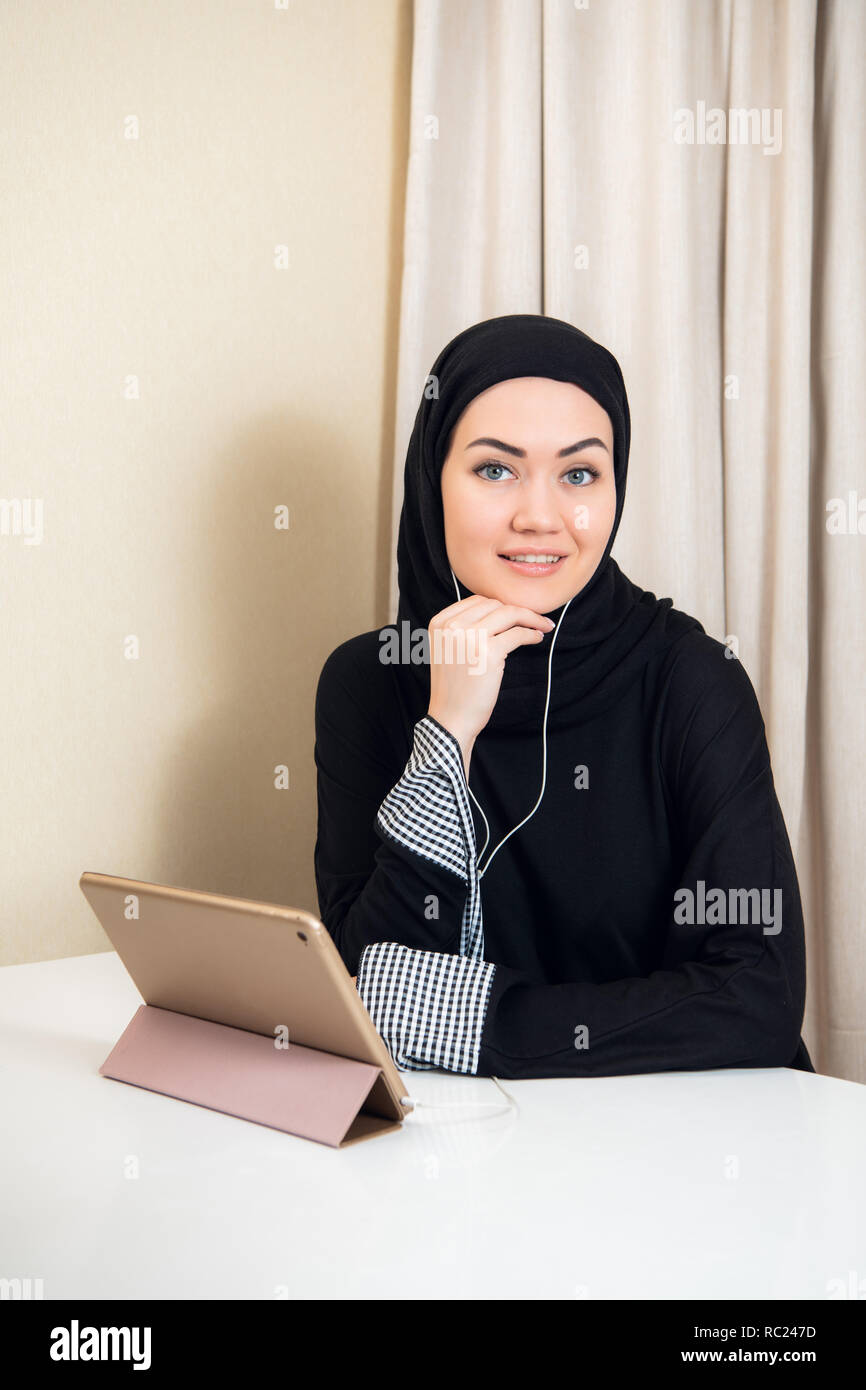 Arabic woman using tablet pc computer. Southeast Asian student at home ...