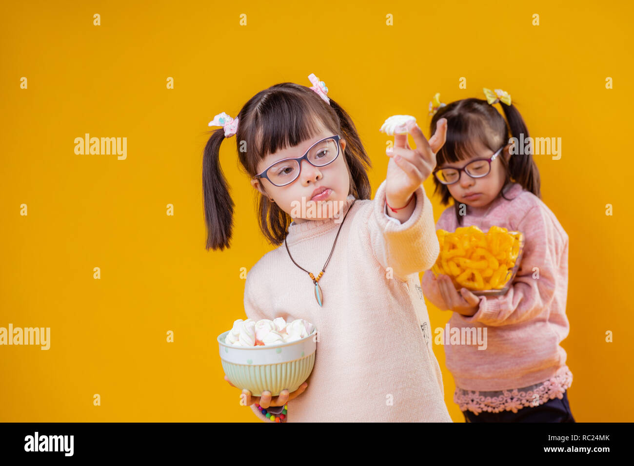 Two adorable children with down syndrome carrying tasty snacks Stock ...