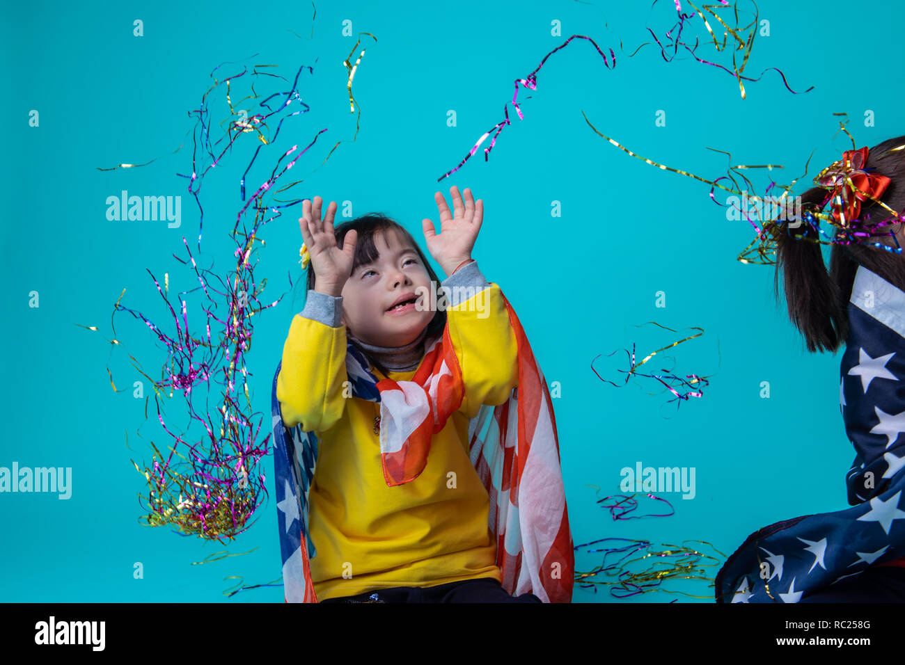 Happy little girl with down syndrome throwing colored ribbons Stock ...
