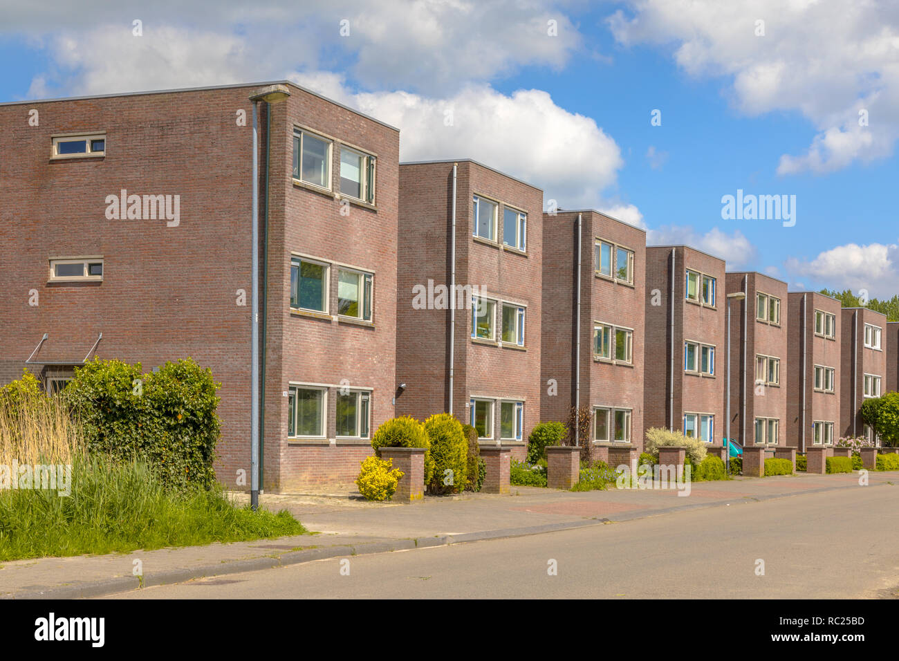 Modern street with large detached family houses in suburb in Groningen ...