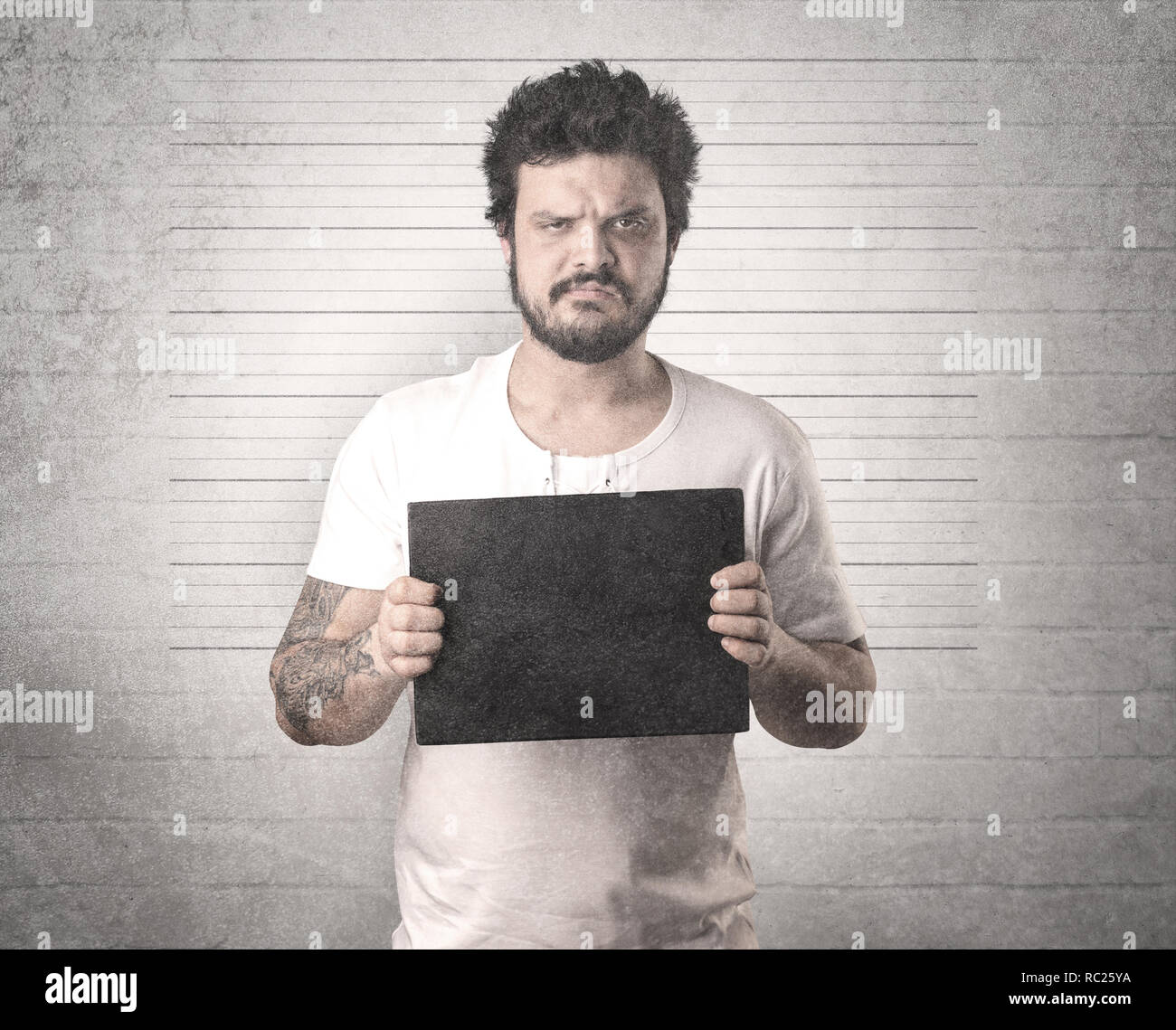 Gangster in front of a wall with table on his hand Stock Photo - Alamy