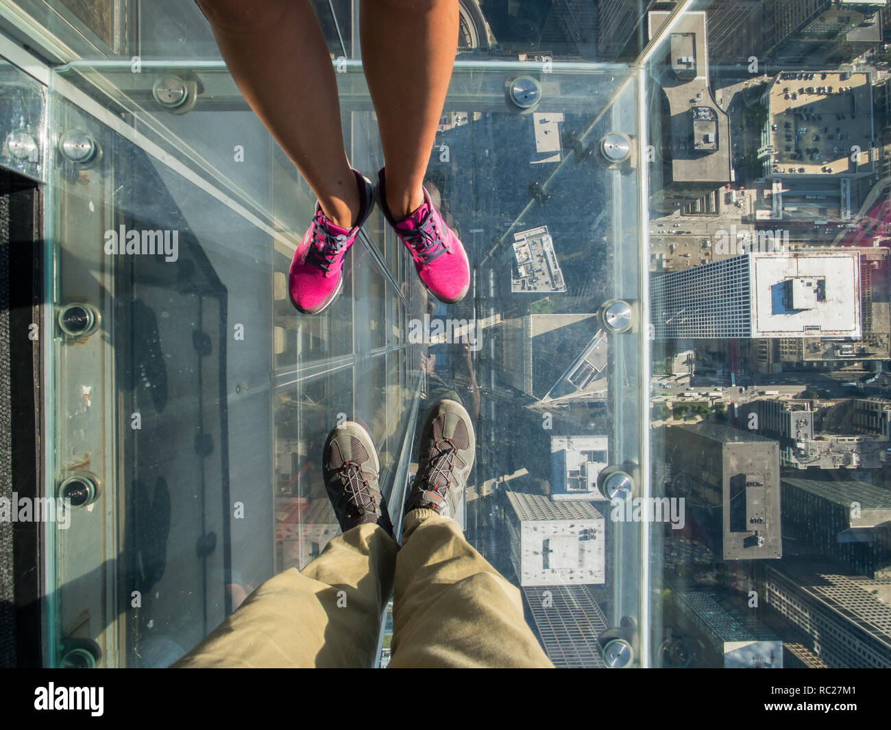 Tourists posing on a glass floor Stock Photo - Alamy