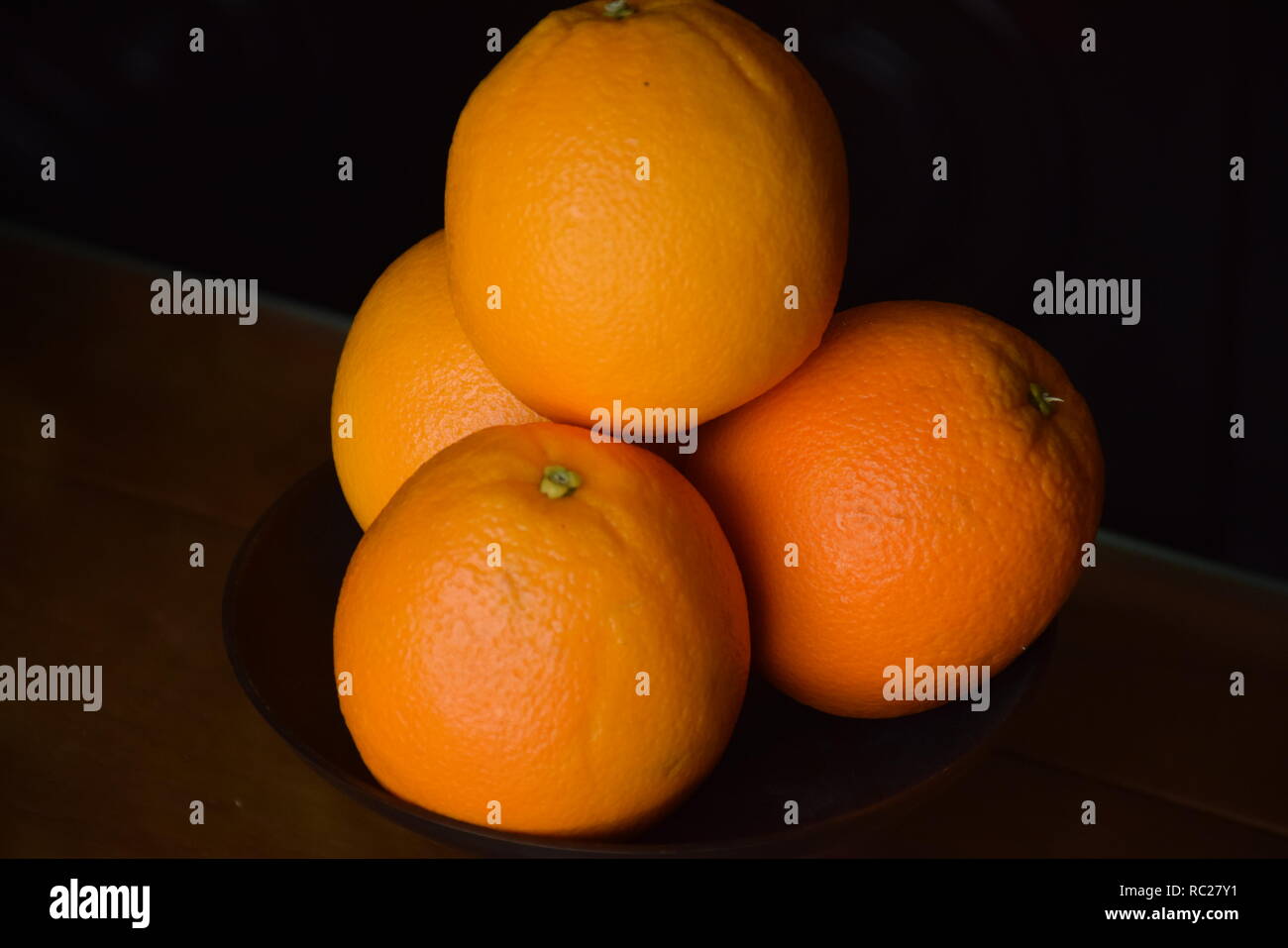 Close up of a group of four oranges with dark background Stock Photo ...