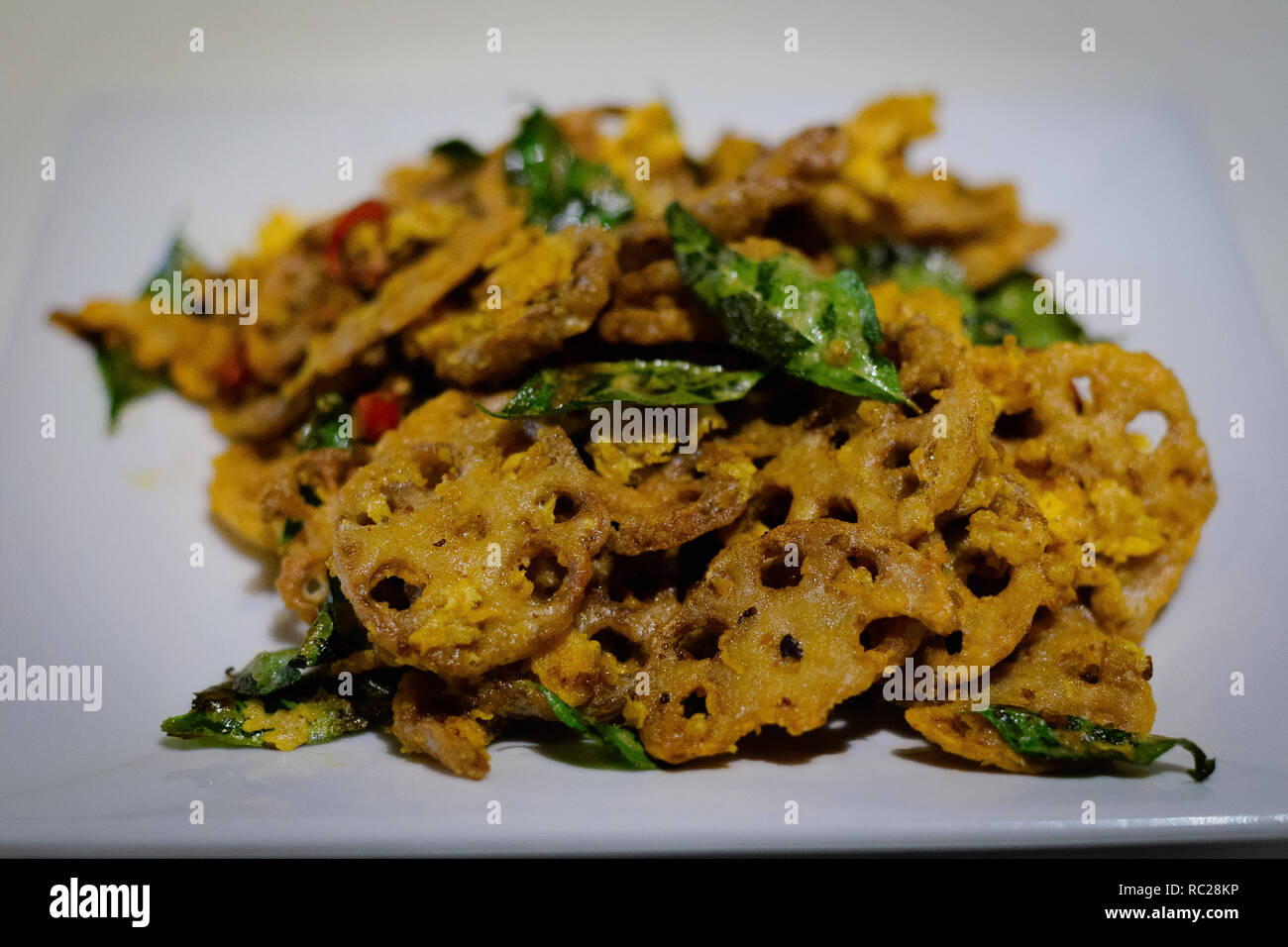 deep fried Salted Egg Lotus Root with basil Stock Photo - Alamy