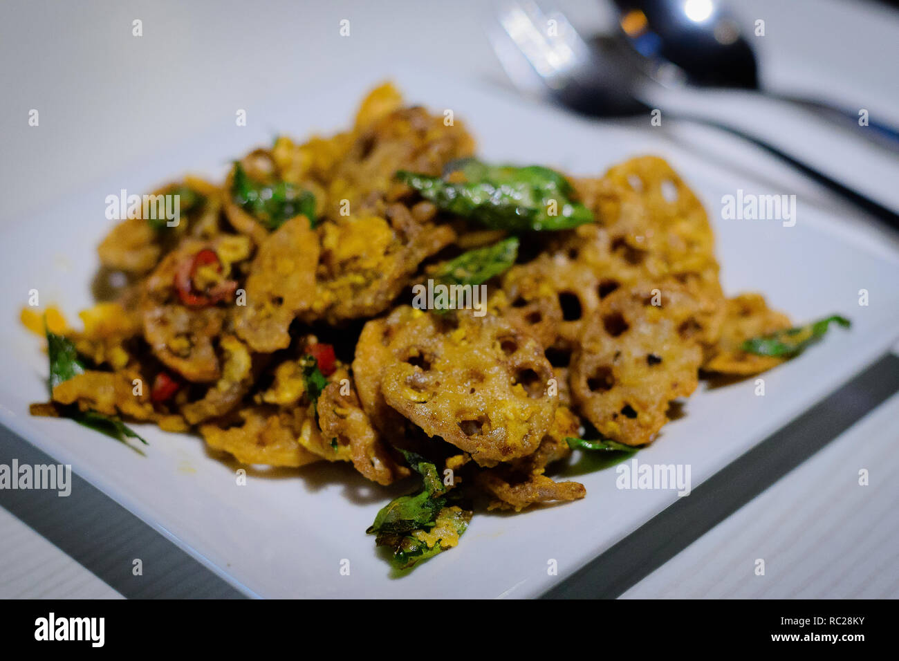 deep fried Salted Egg Lotus Root with basil Stock Photo - Alamy