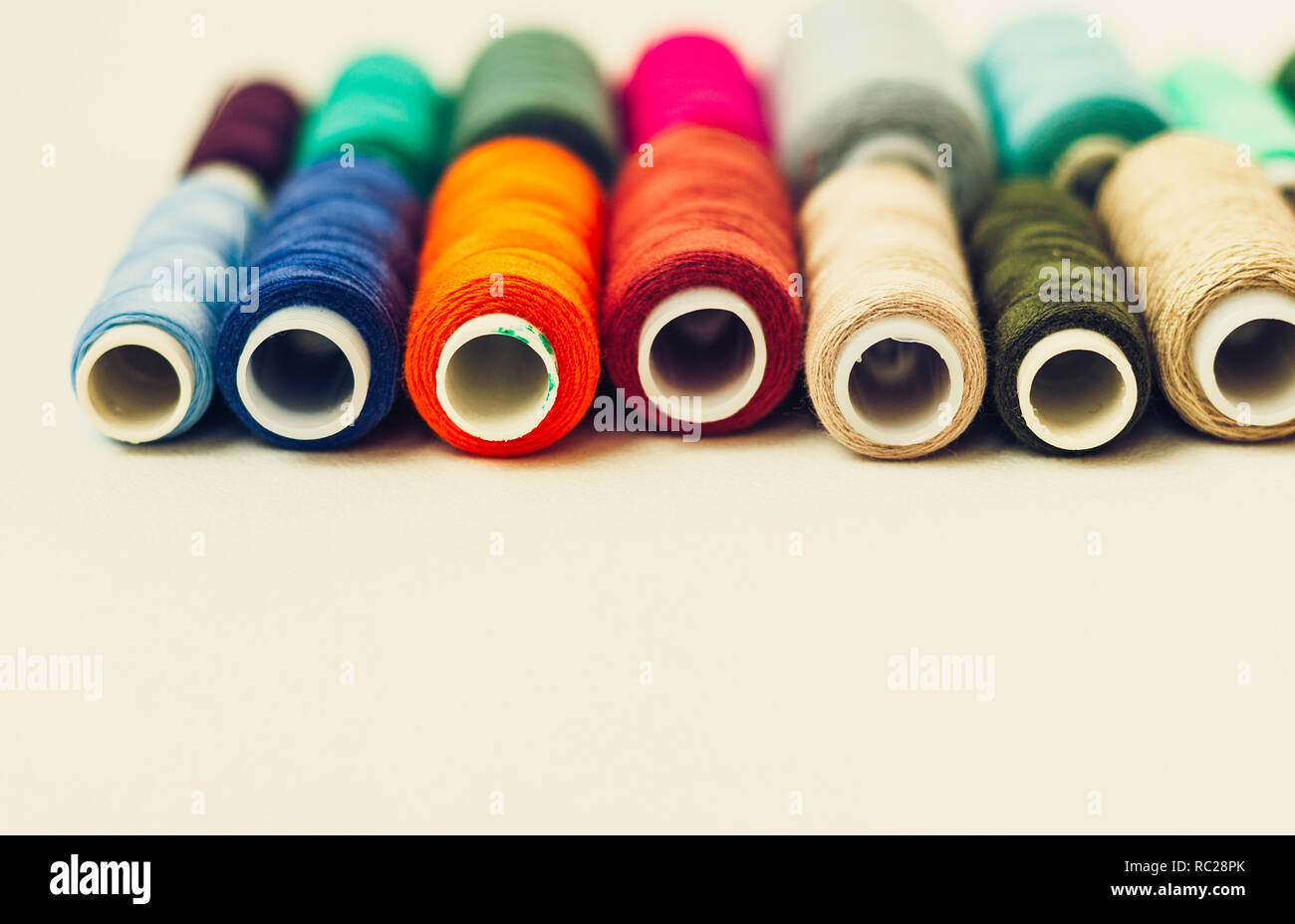 Colored sewing thread coils on white background with copy space for ...