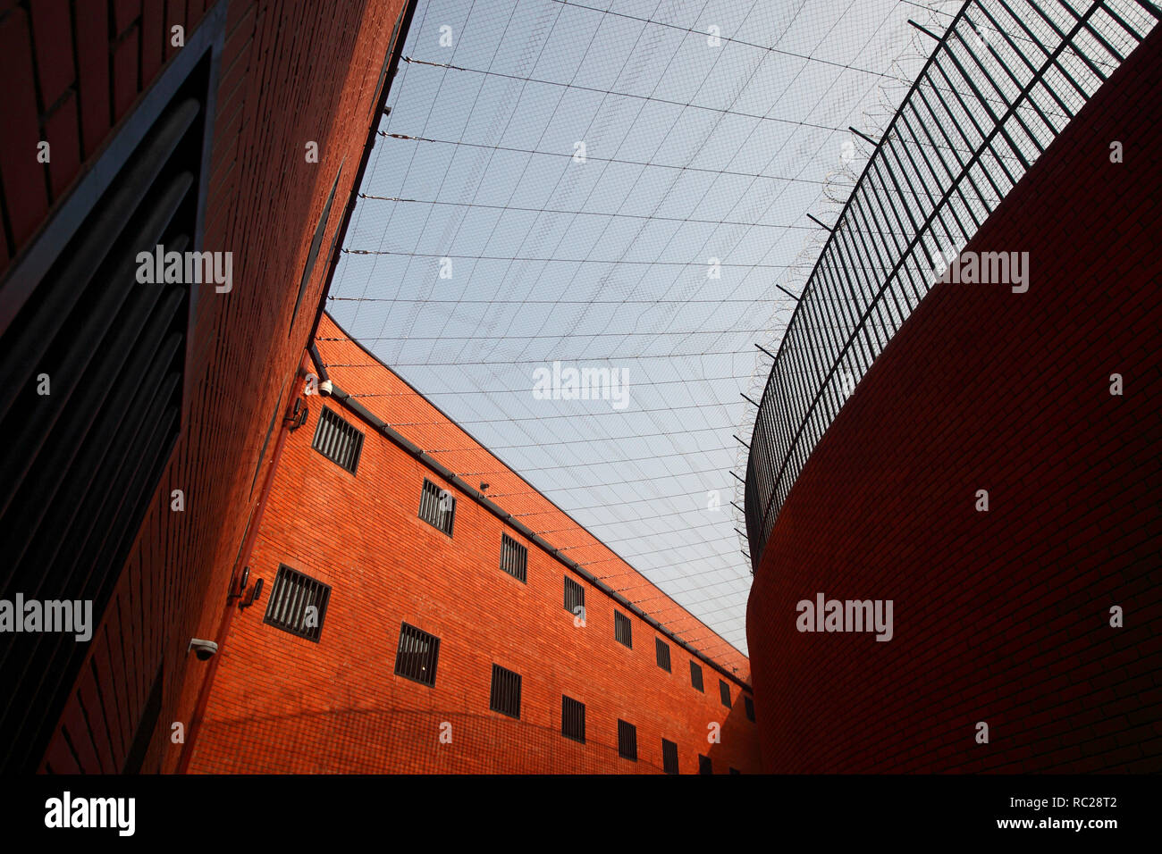 Brick jail building with prison fence with barbed wire Stock Photo - Alamy
