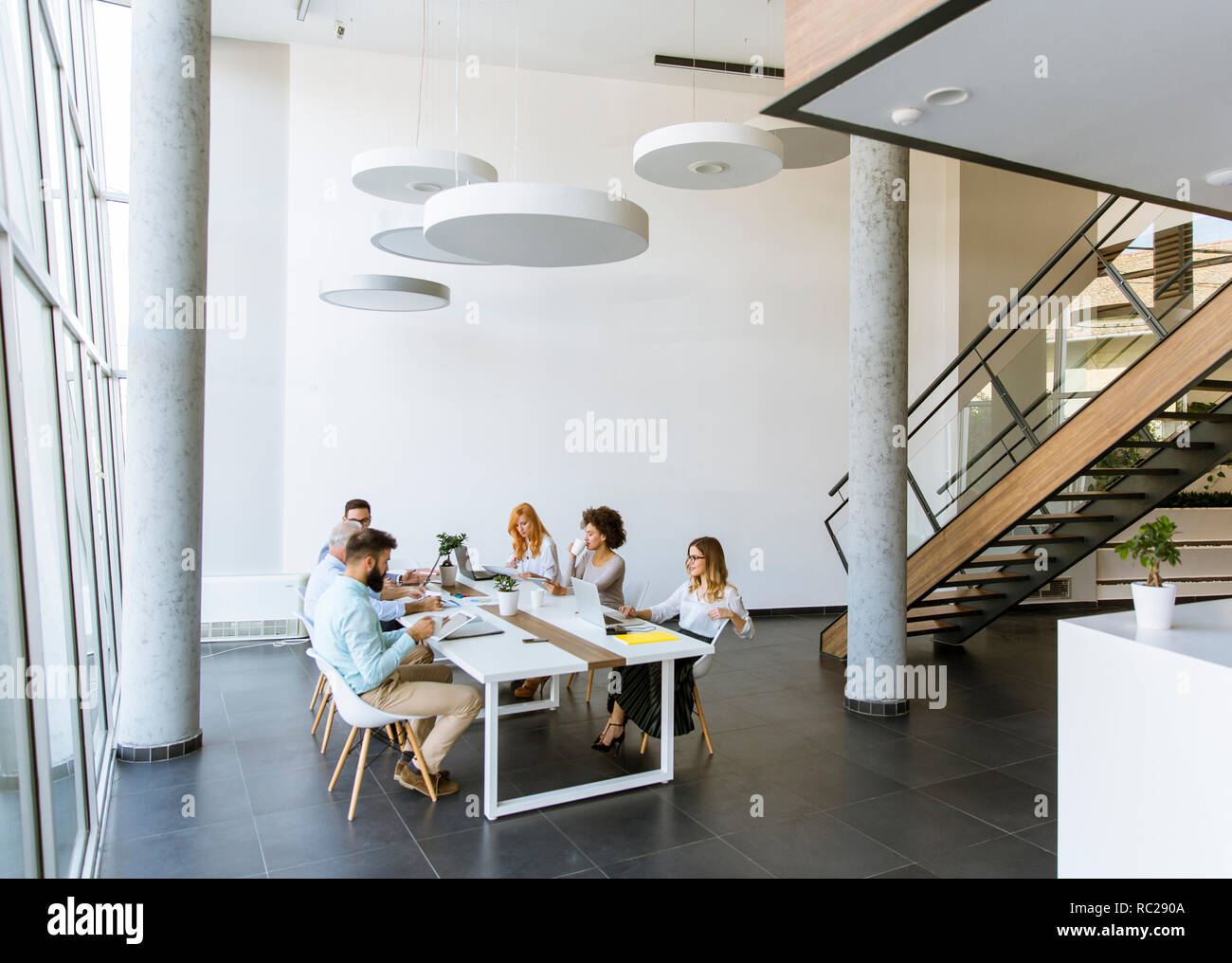 View of multiracial business people around table during staff meeting ...
