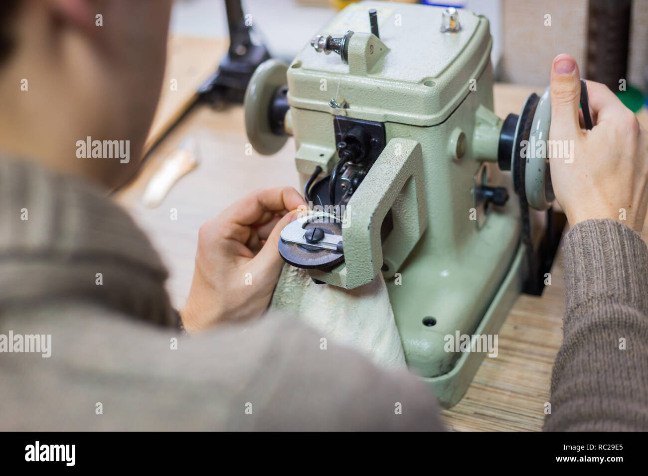 Professional male skinner, furrier using special sewing machine for ...