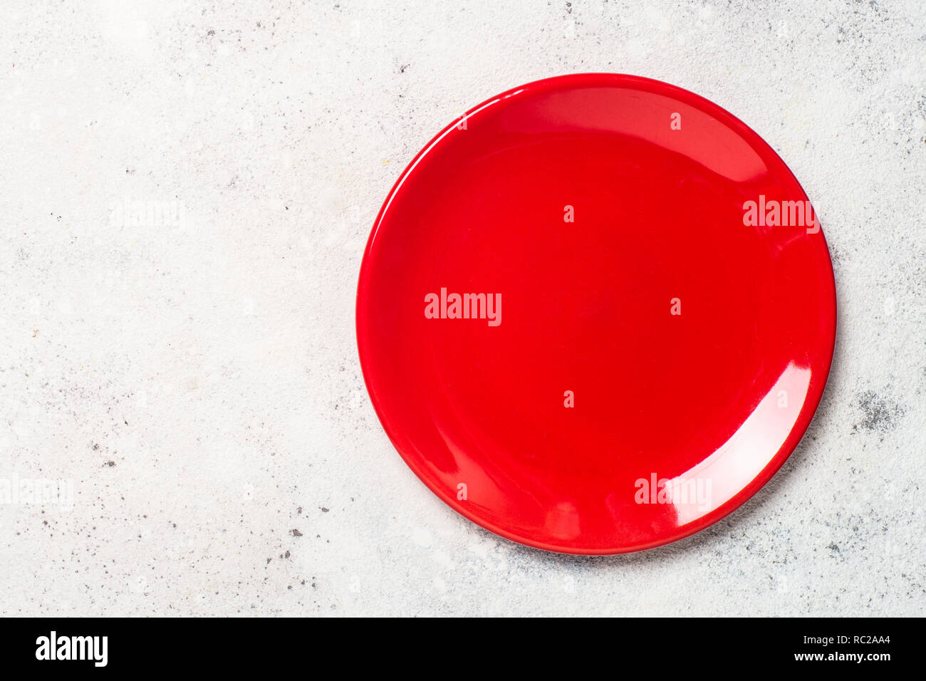Red plate on light stone table top view Stock Photo - Alamy
