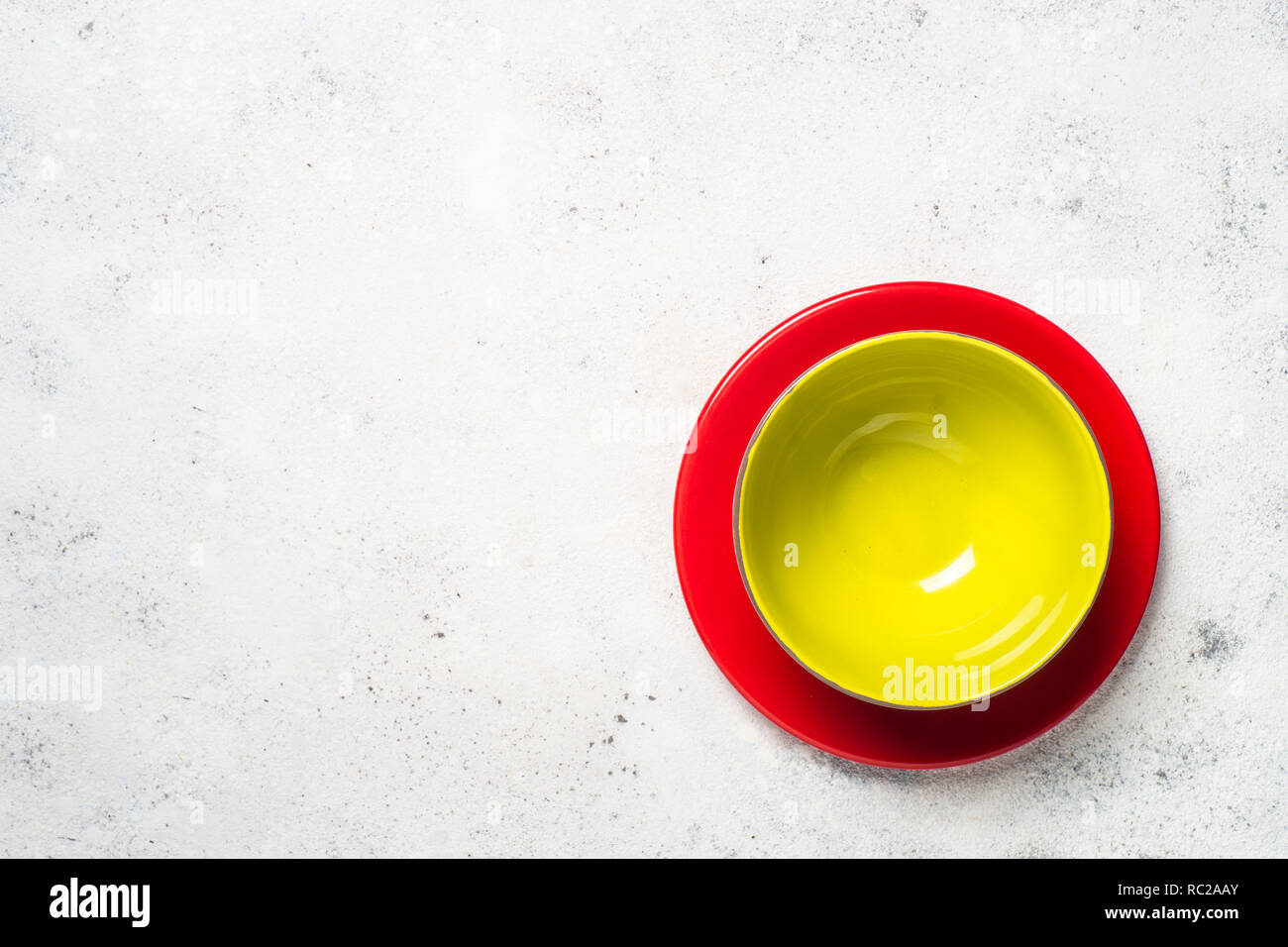 Colored dinnerware - red and green plates on light stone table Stock ...