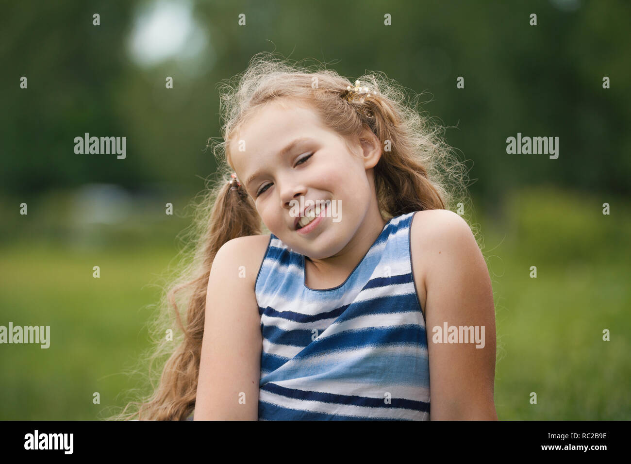 Pretty smiling child posing in park, outdoor portrait Stock Photo - Alamy