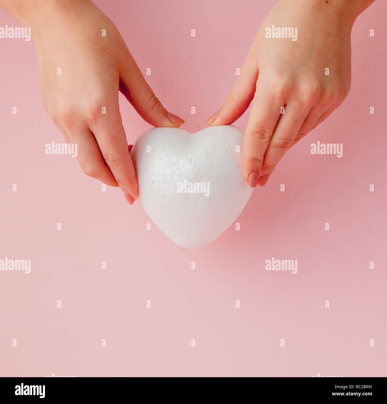 White empty love heart in hands on pink background Stock Photo - Alamy