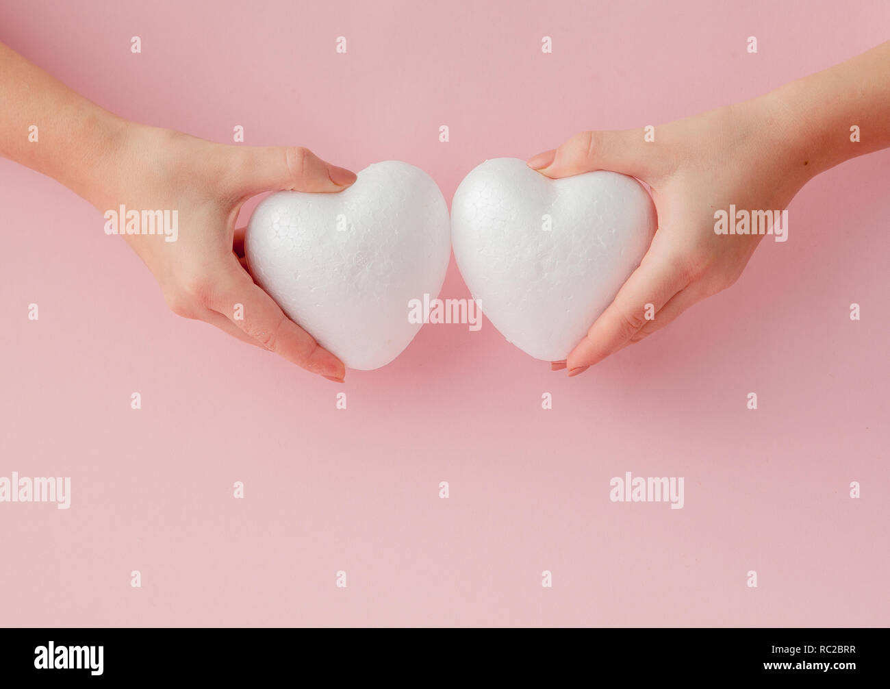 White empty love hearts in hands on pink background Stock Photo - Alamy