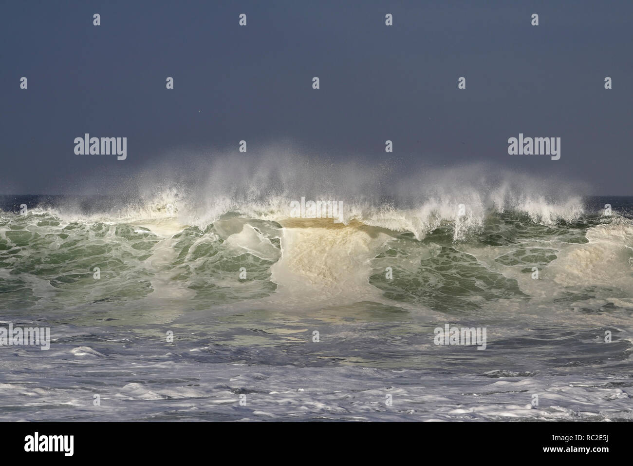 Spraying sea wave with beautiful light Stock Photo - Alamy