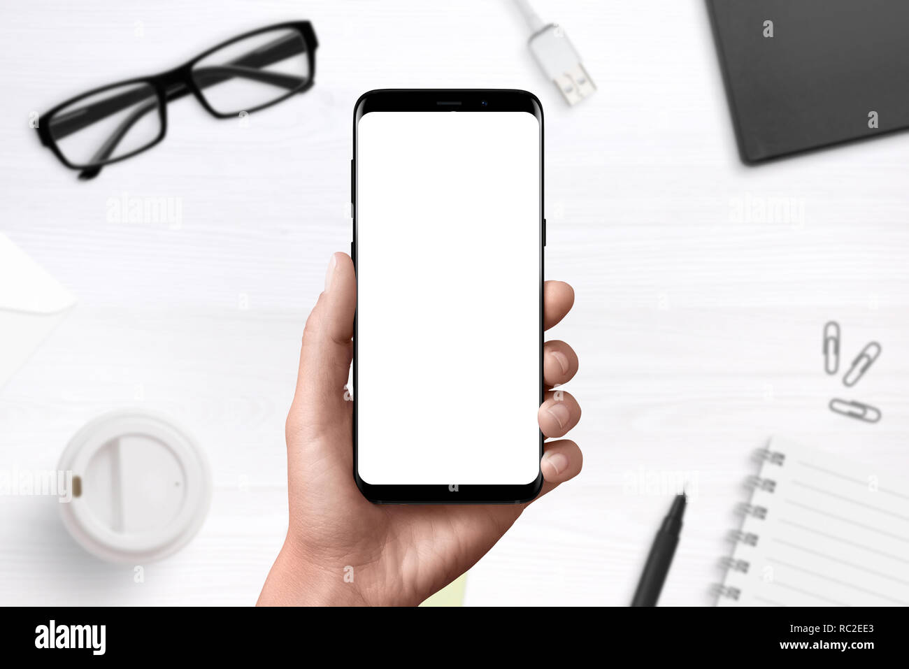 Modern smart phone ih hand with isolated, blank display for mockup, ap ...