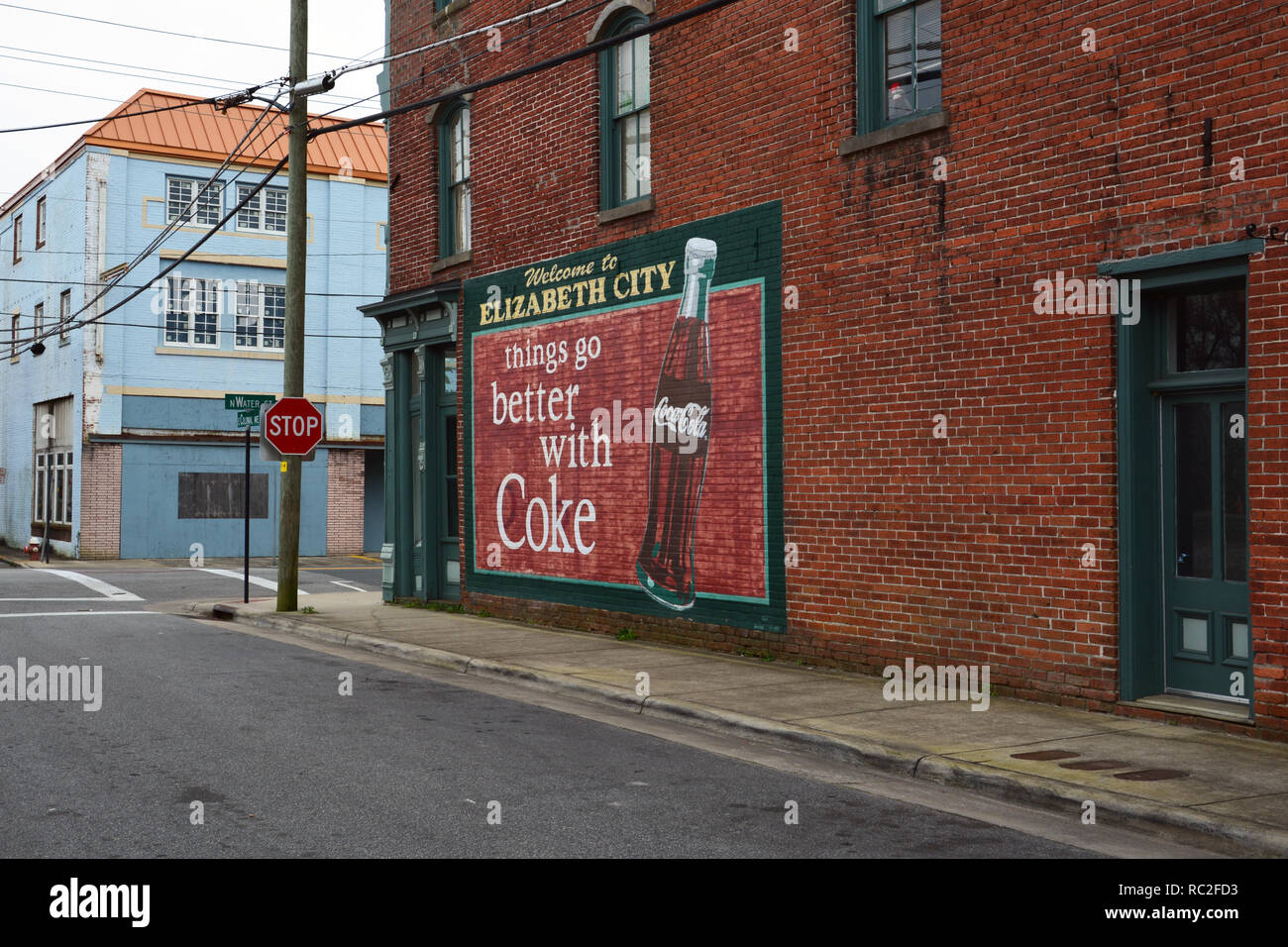 A classic sign for Coca Cola on the side of an old corner store in the ...
