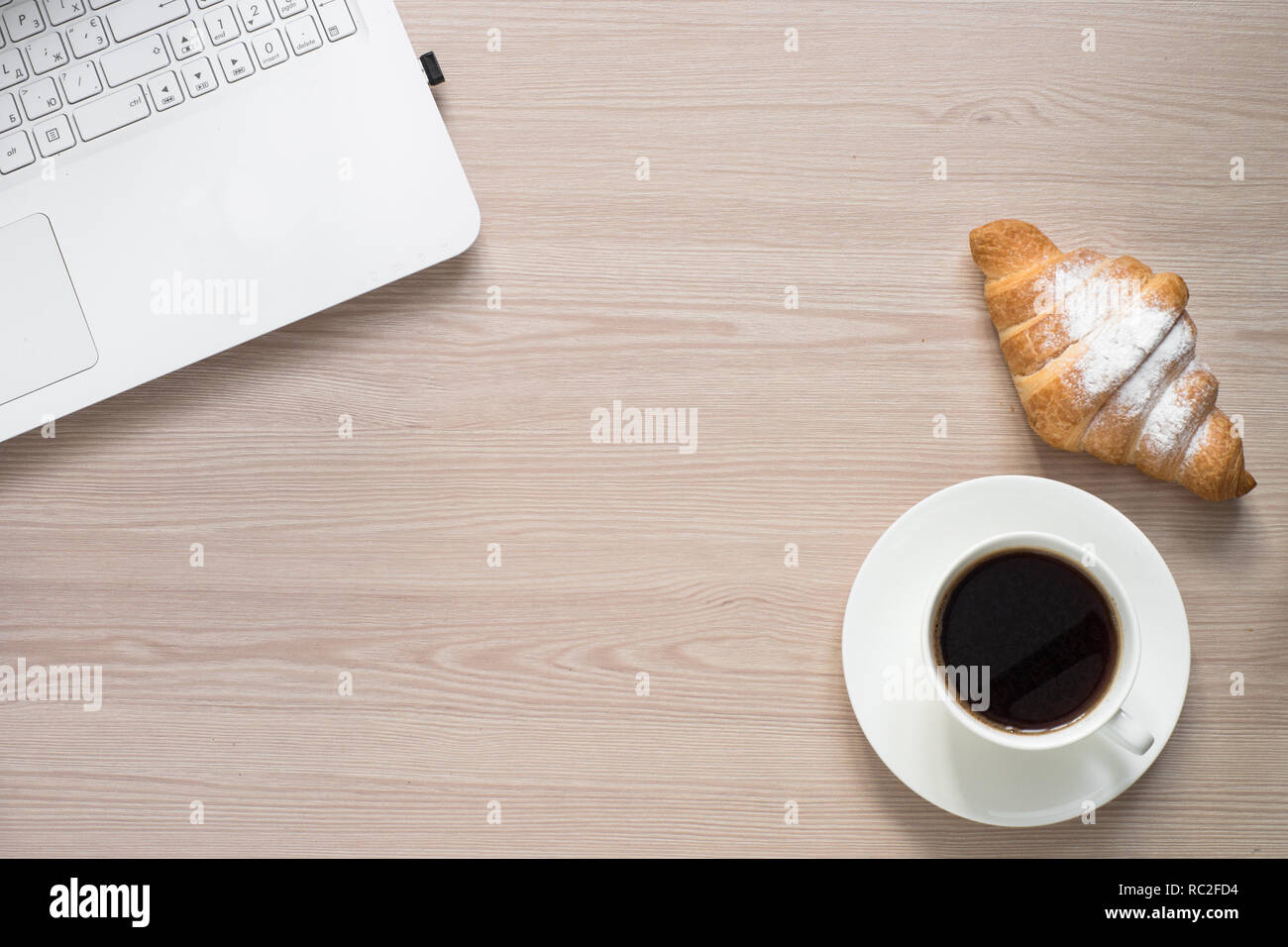 Laptop, coffee and croissant at desk table Stock Photo - Alamy