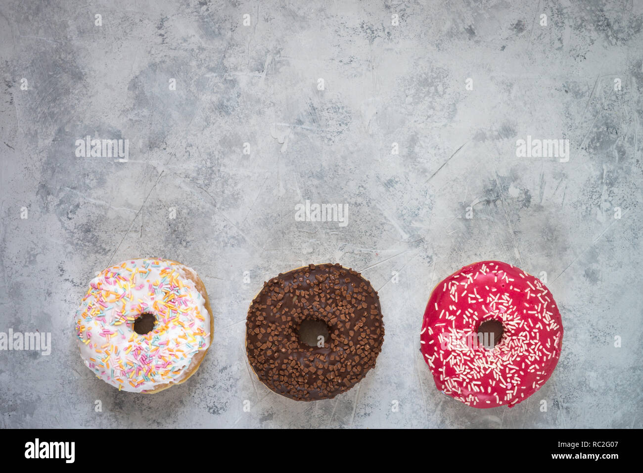 Colorful donuts at concrete table Stock Photo - Alamy