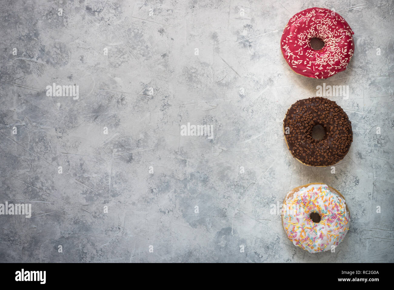 Colorful donuts at concrete table Stock Photo - Alamy