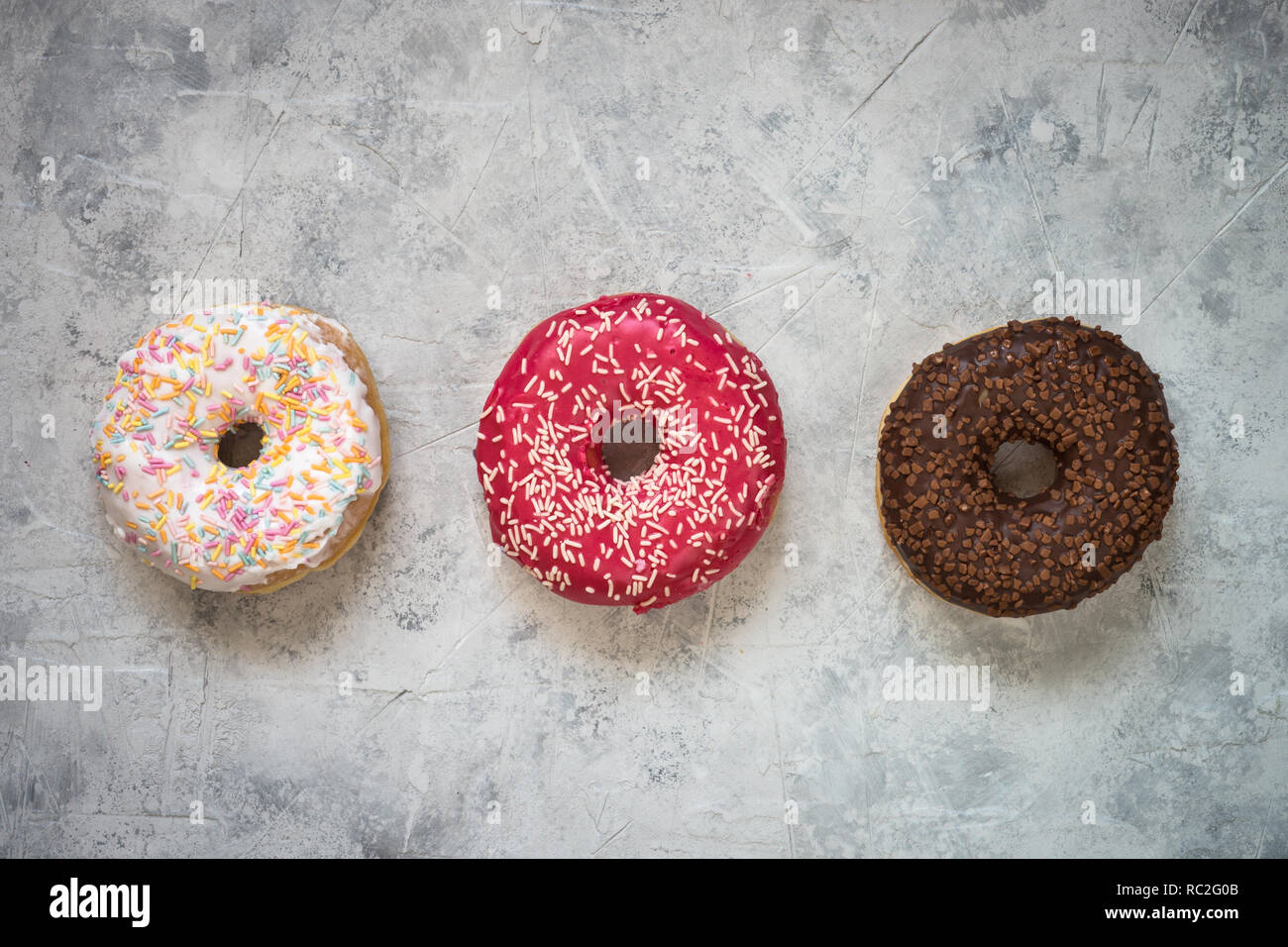 Colorful donuts at concrete table Stock Photo - Alamy