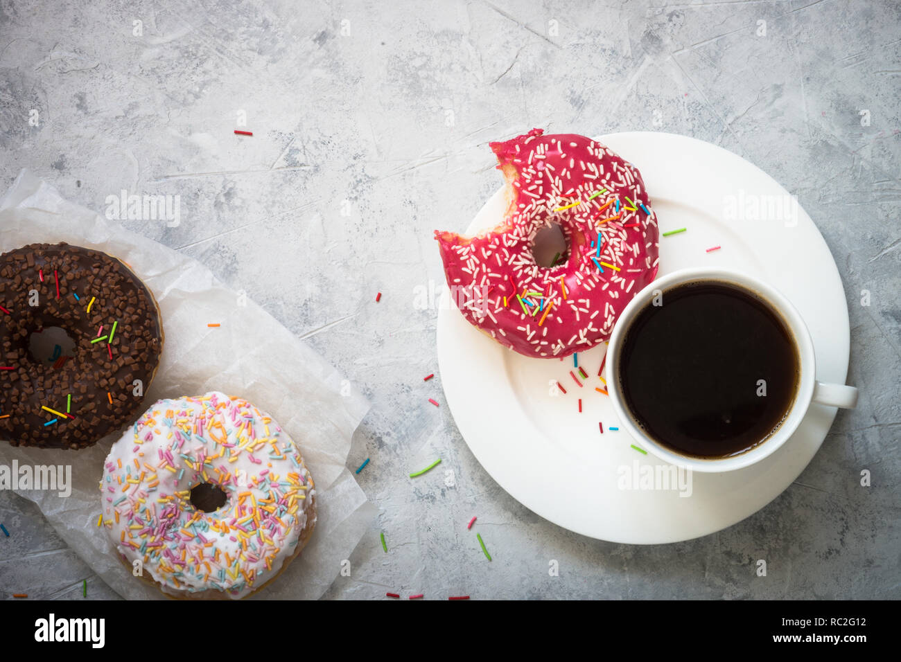 Colorful donuts at concrete table Stock Photo - Alamy