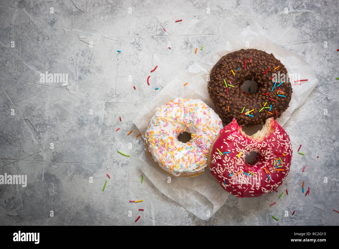 Colorful donuts at concrete table Stock Photo - Alamy